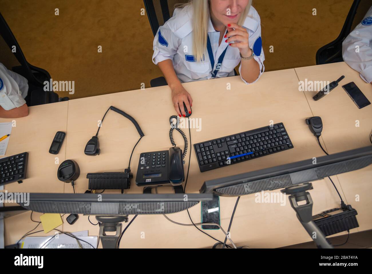 Female security guards working on computers while sitting in the main ...