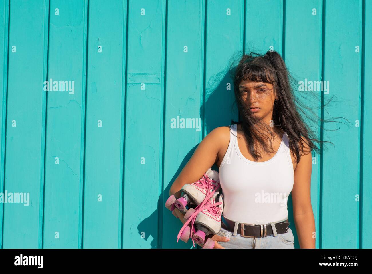 Young lady holding her roller skates in her arms Stock Photo - Alamy
