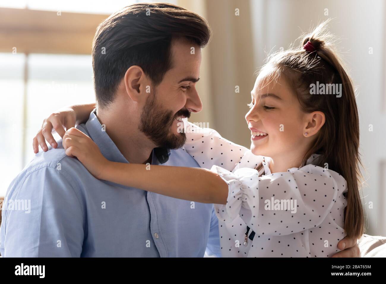 Affectionate young daddy embracing little kid daughter Stock Photo - Alamy
