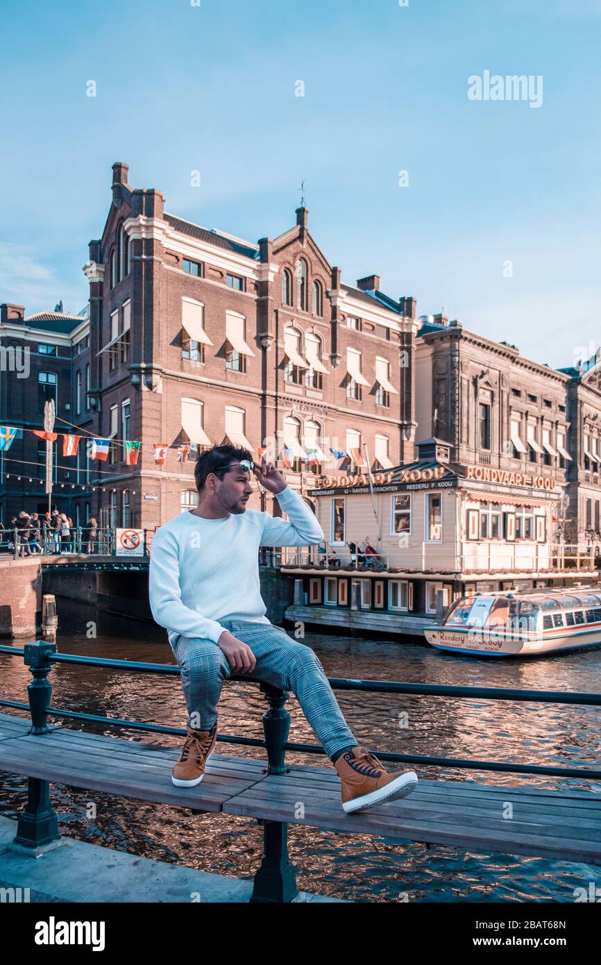 young guy on city trip Amsterdam Netherlands, men visiting the canals ...