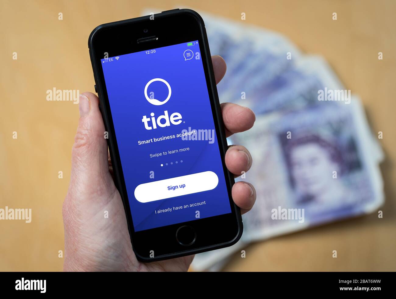 A woman using the tide banking app on a mobile phone. (Editorial Use ...