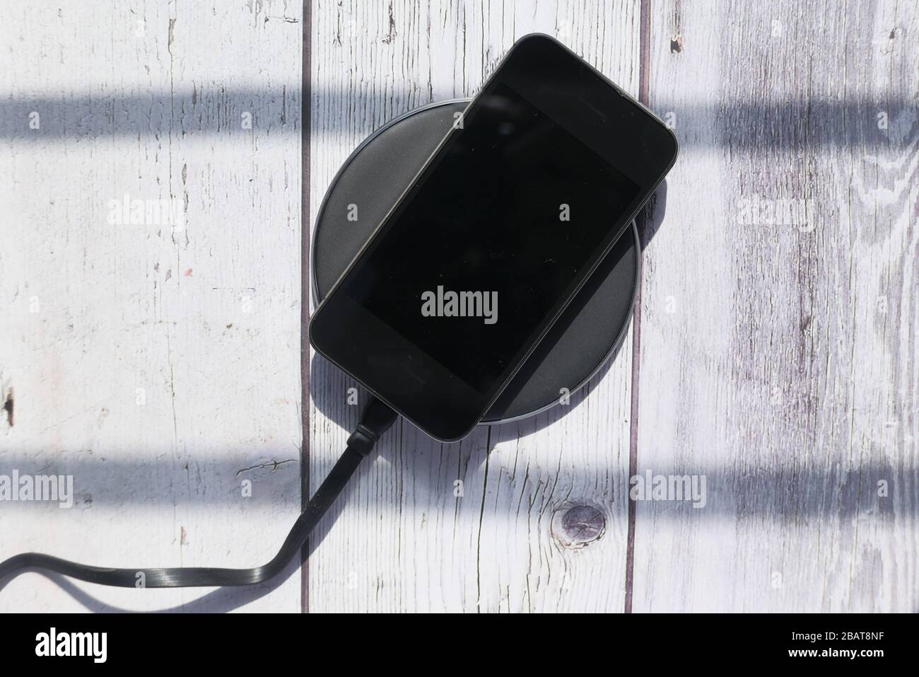 top view of smart phone charging on table Stock Photo - Alamy