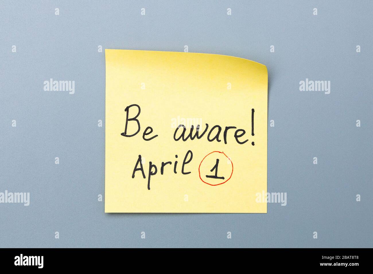 be aware on yellow sticky note over a grey background. april fools day ...