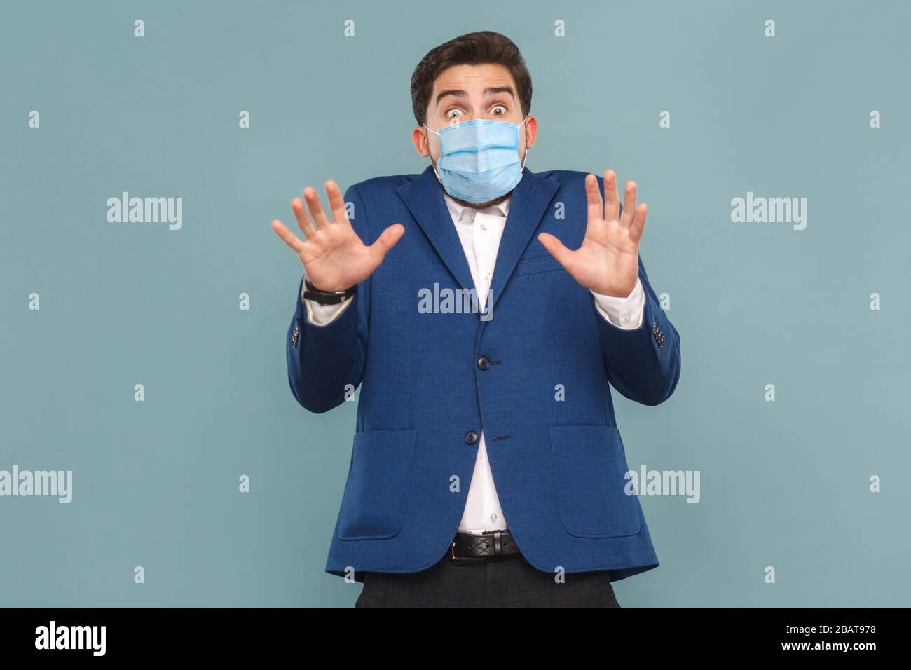 Portrait of afraid young shocked man with surgical medical mask ...