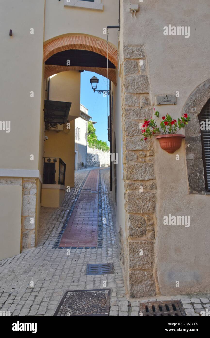 A narrow street between the stone houses of Prossedi, a medieval ...