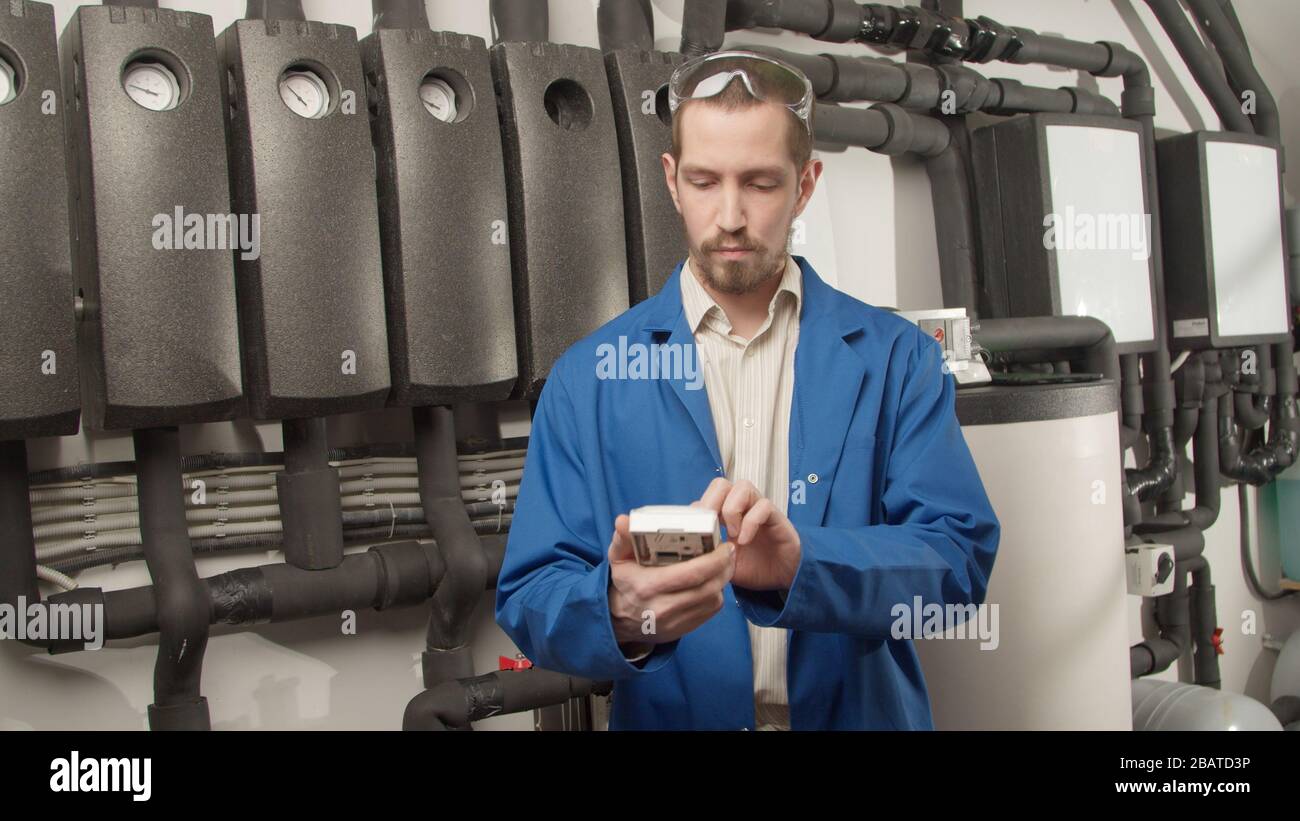 Young engineer checking new equipment with controller Stock Photo - Alamy