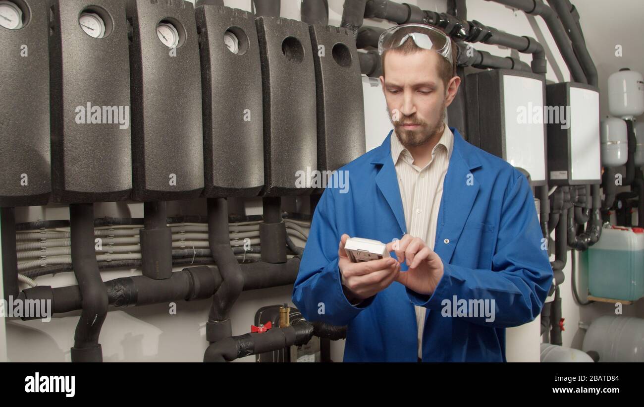 Young engineer checking new equipment with controller Stock Photo - Alamy