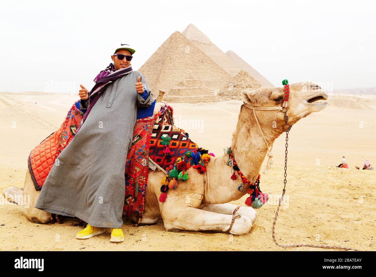 A camel driver poses by a camel on the Giza Plateau at Cairo, Egypt ...