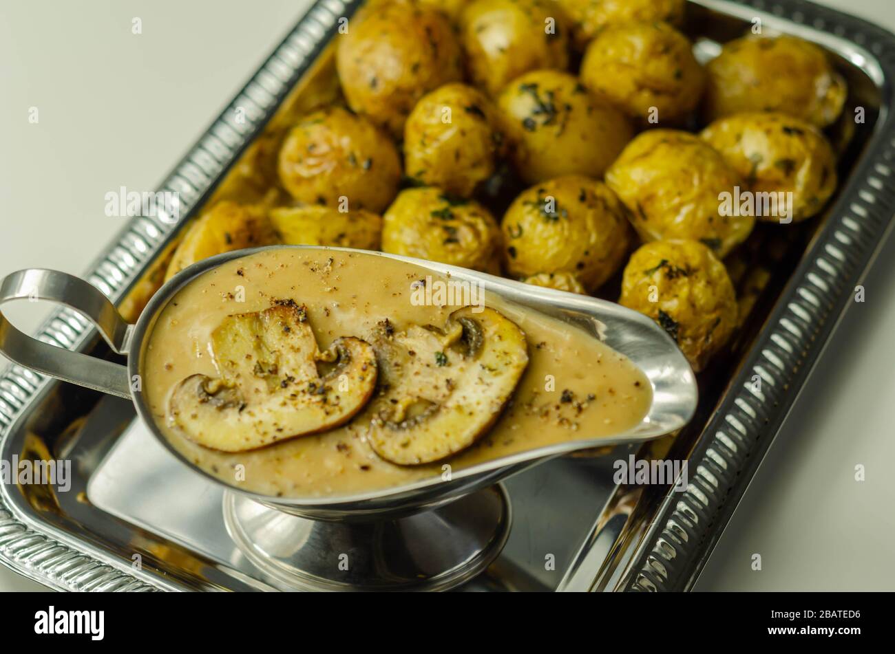 Mini jacket potatoes with mushrooms sauce on the silver tray, delicious ...