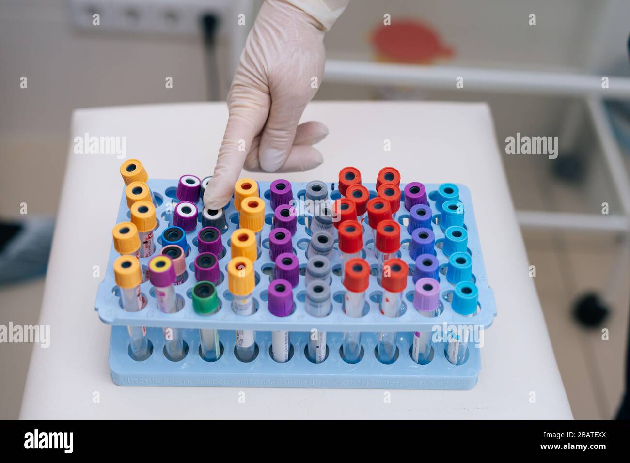 Doctor wearing rubber gloves points his hand at medical blood ...