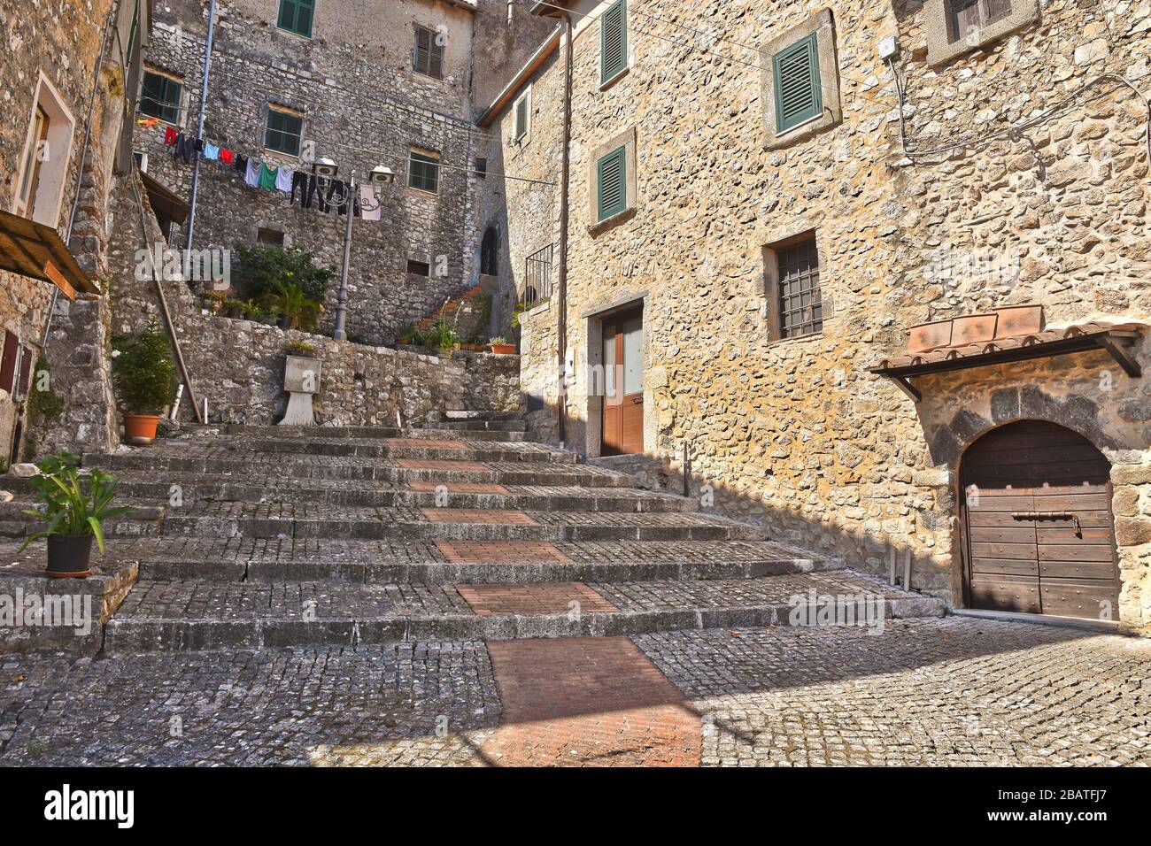 A narrow street between the stone houses of Prossedi, a medieval ...