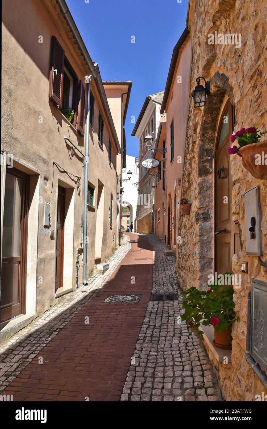 A narrow street between the stone houses of Prossedi, a medieval ...