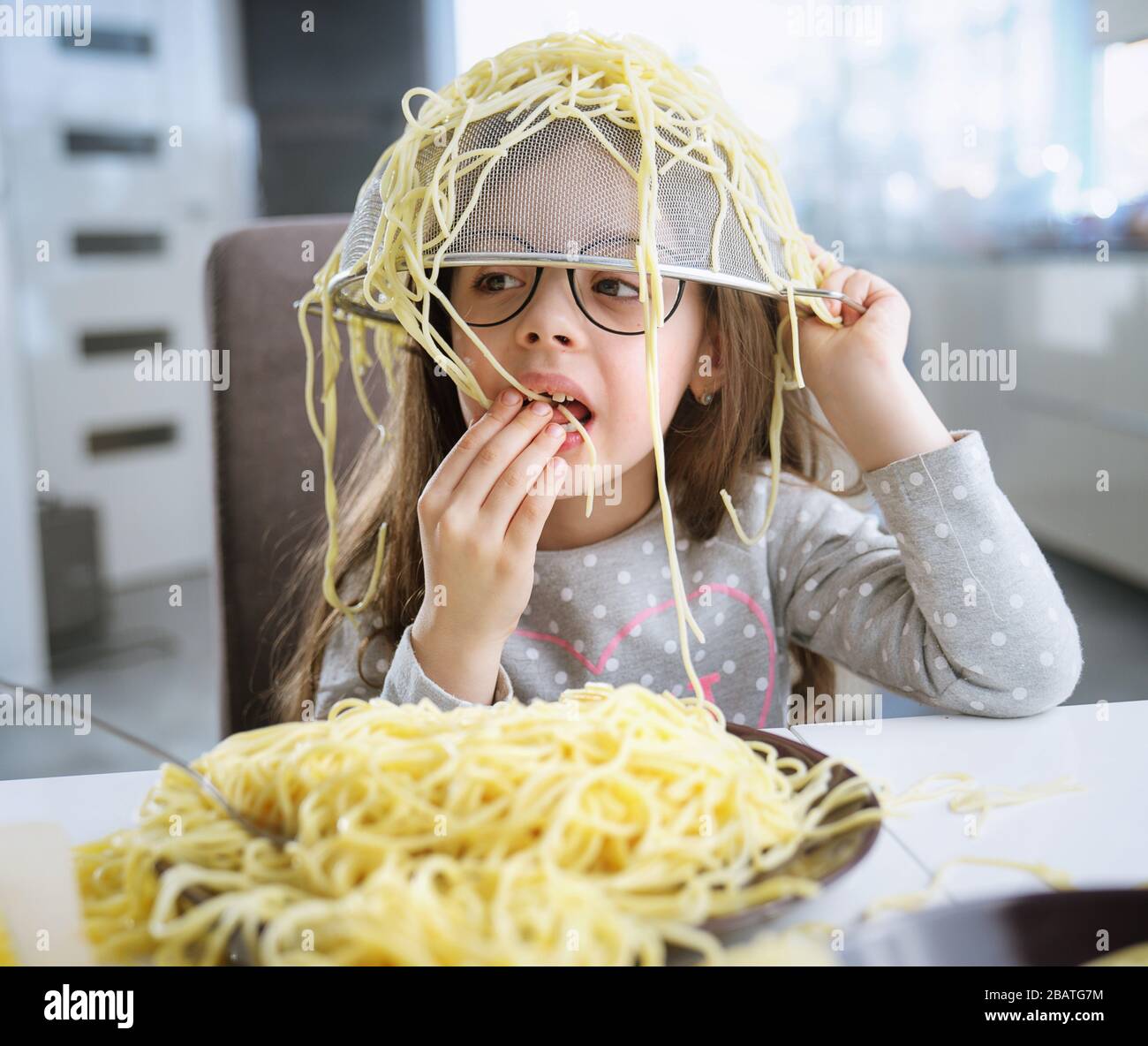 Portrait of a little, cute girl eating a spaghetti pasta Stock Photo ...