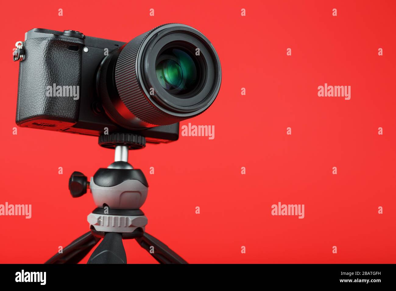 Professional camera on a tripod, on a red background. Record videos and ...