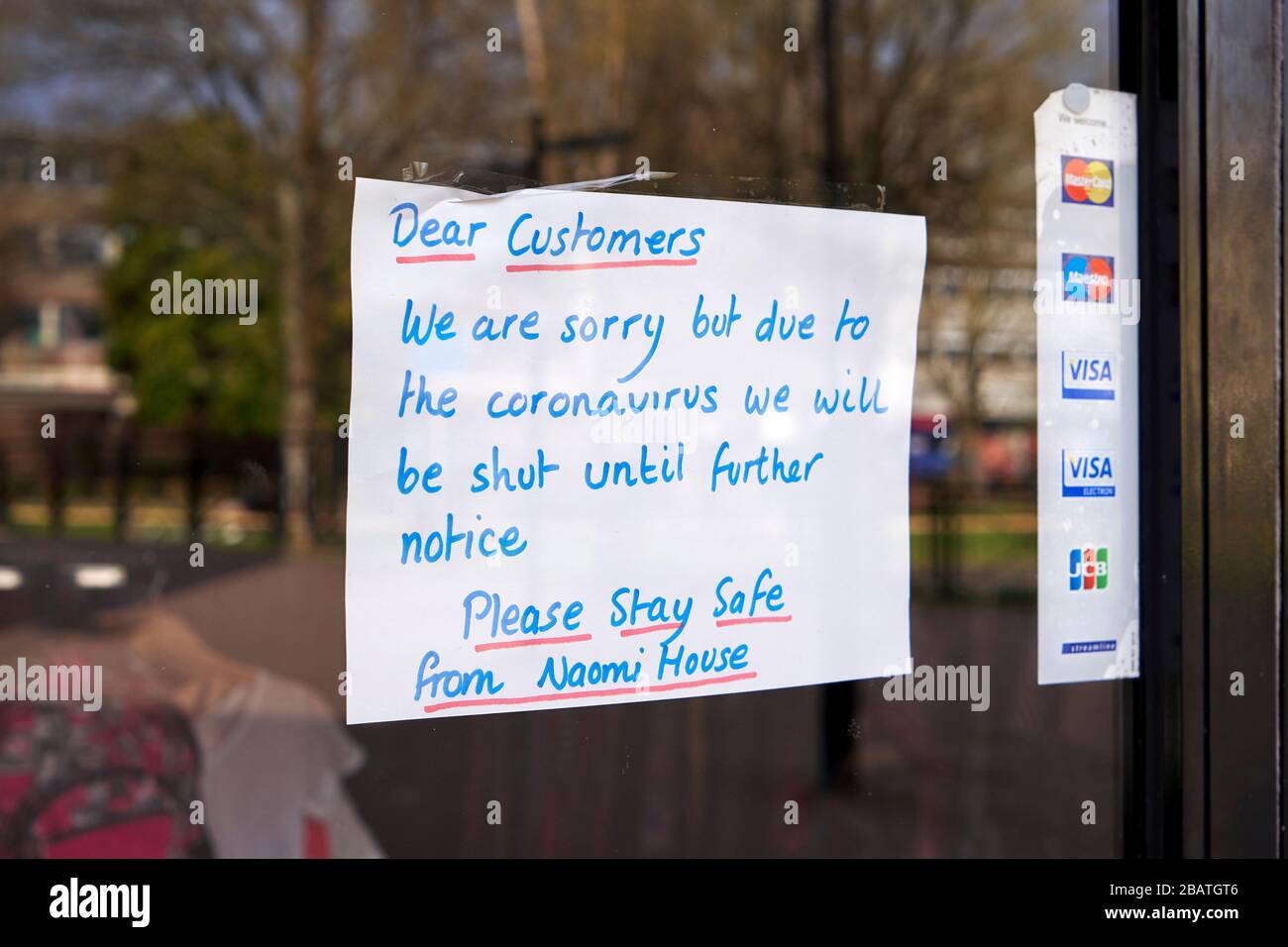 Hand written customer notice in the window of the Naomi House charity ...