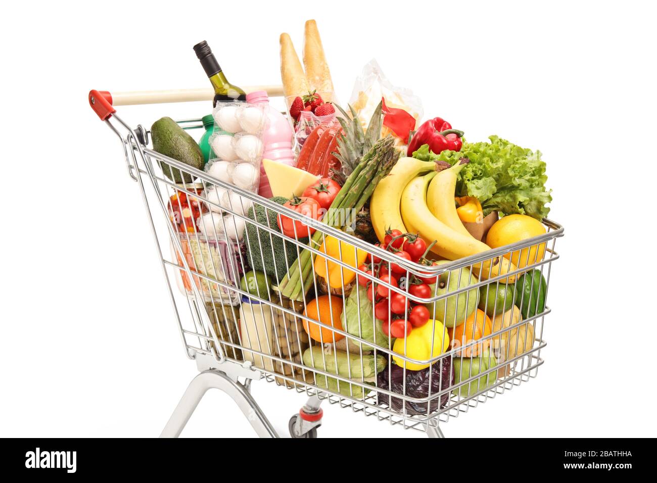 Close up of a shopping cart with food isolated on white background ...