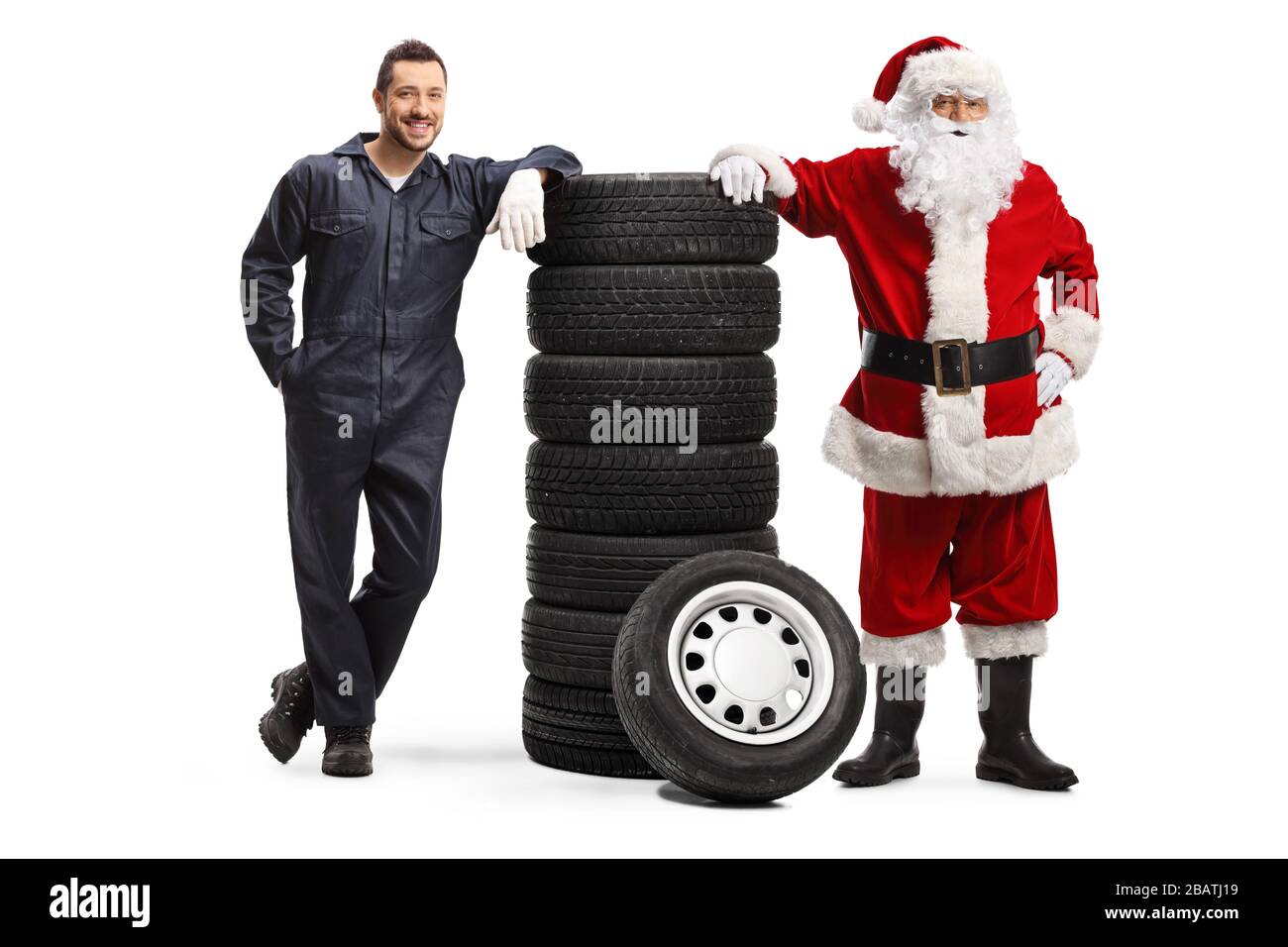 Auto mechanic and Santa Claus posing with a pile of tires isolated on ...