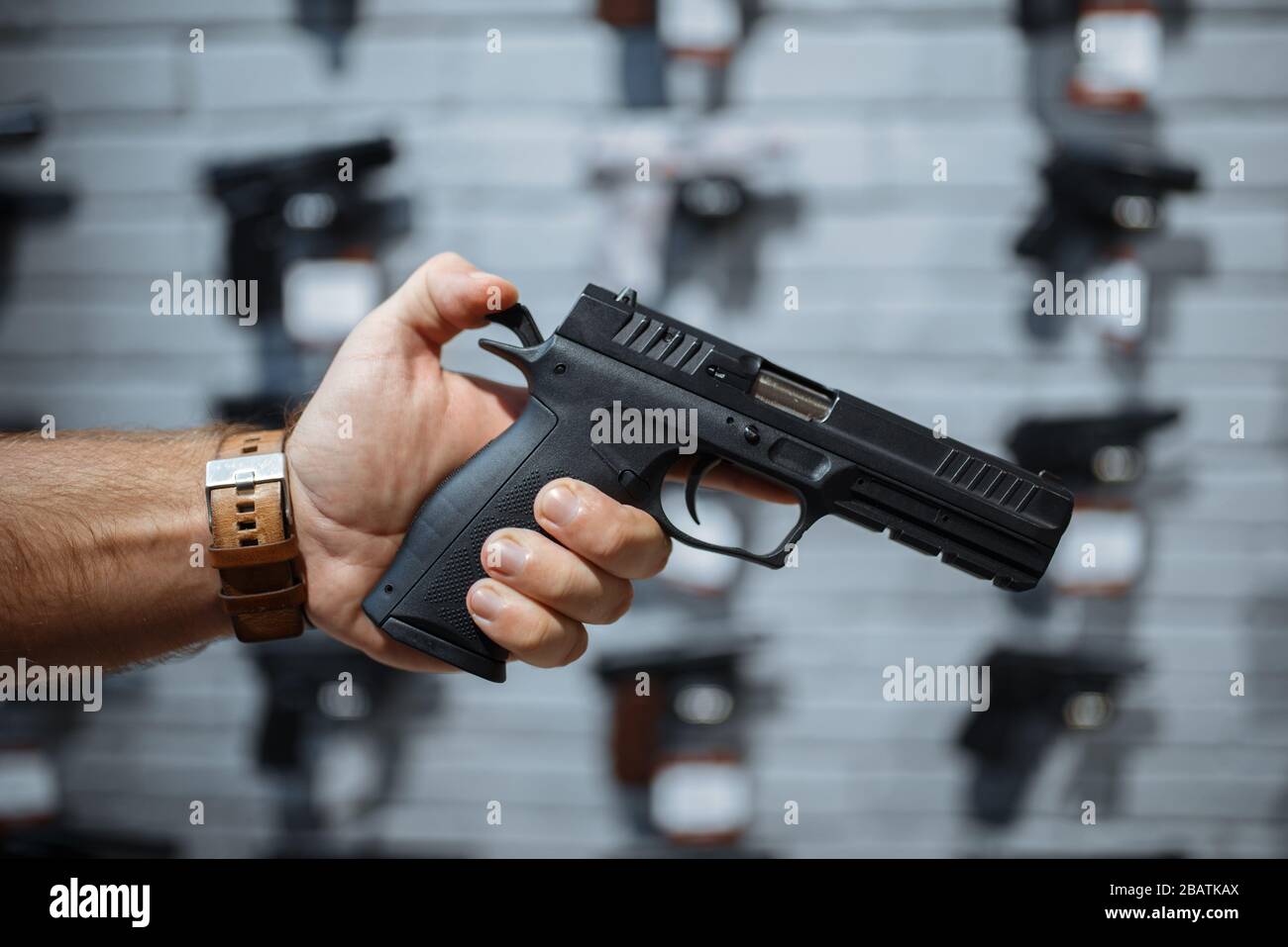 Man choosing new handgun in gun shop Stock Photo - Alamy