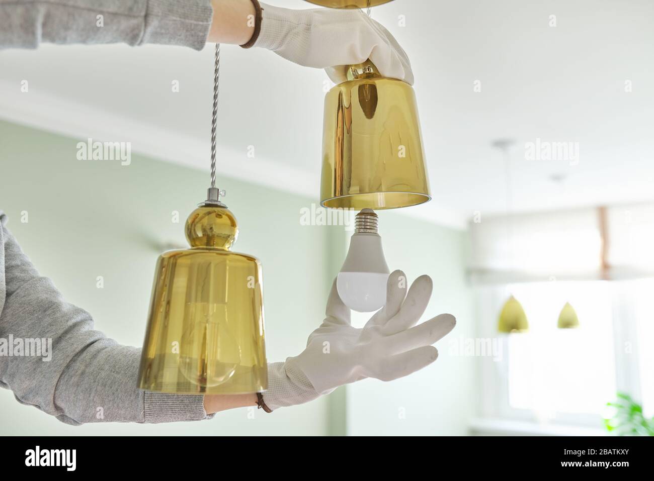 Hands installing LED bulb in lamp, chandelier Stock Photo - Alamy