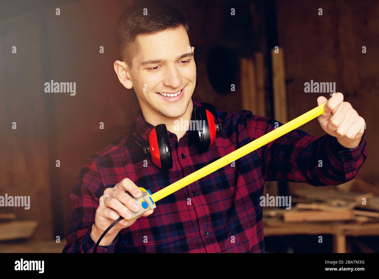 Workman at the sawmill. Young hardworking man Stock Photo - Alamy