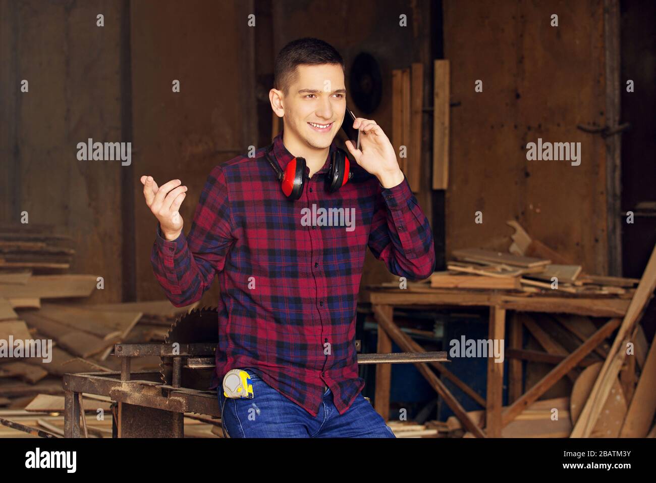 Workman at the sawmill. Young hardworking man Stock Photo - Alamy