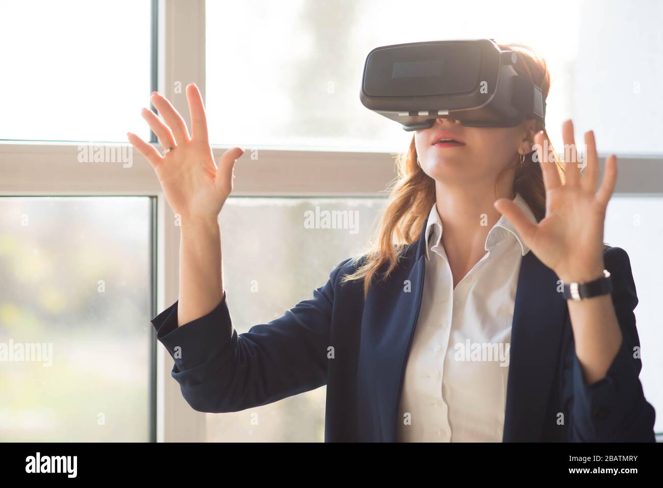 Woman in virtual reality glasses for working remotely and to virtualizate office for future ...