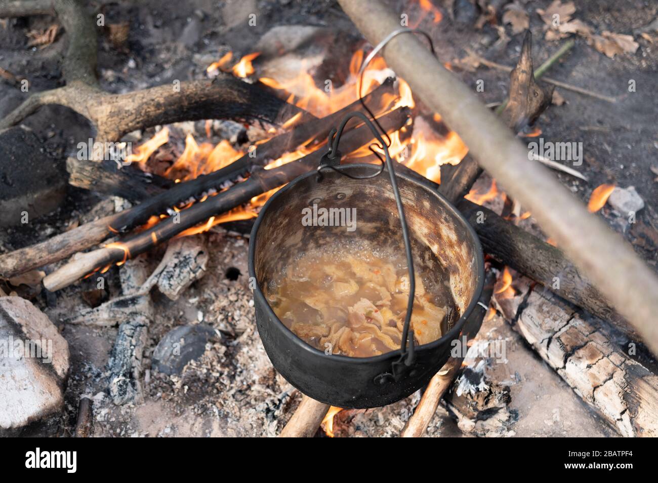 Cooking on fire in the forest. Cooking porridge on a campfire in nature ...