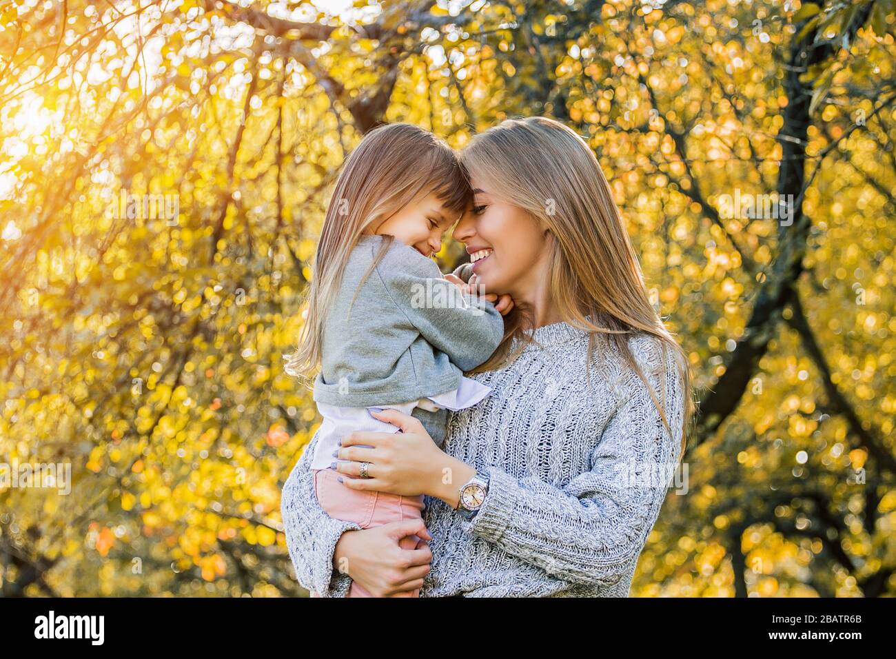 Portrait of loving beautiful woman holding her little girl in hands and ...