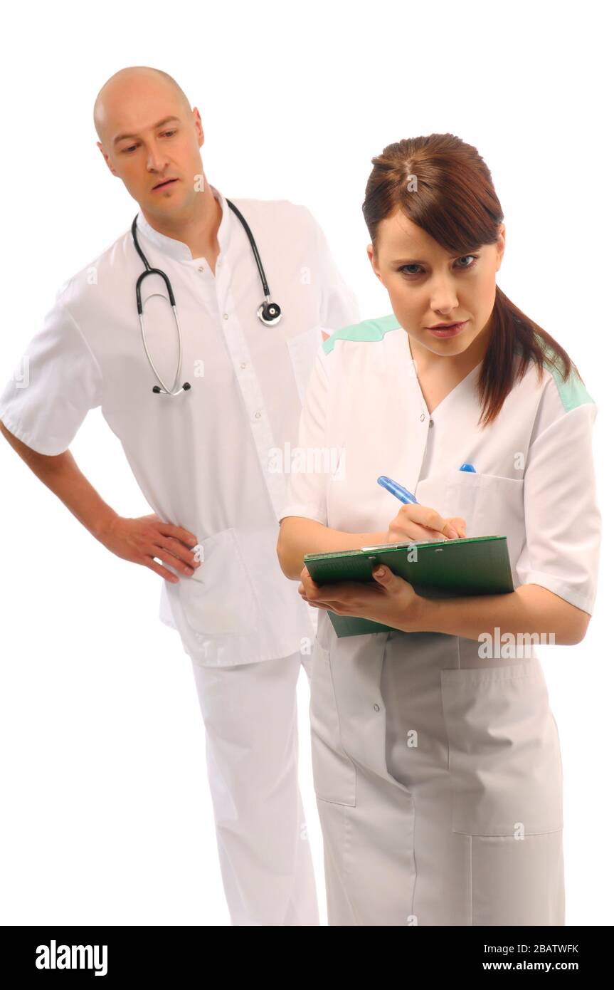 Medical nurse writing notes and doctor reading it over her shoulder ...