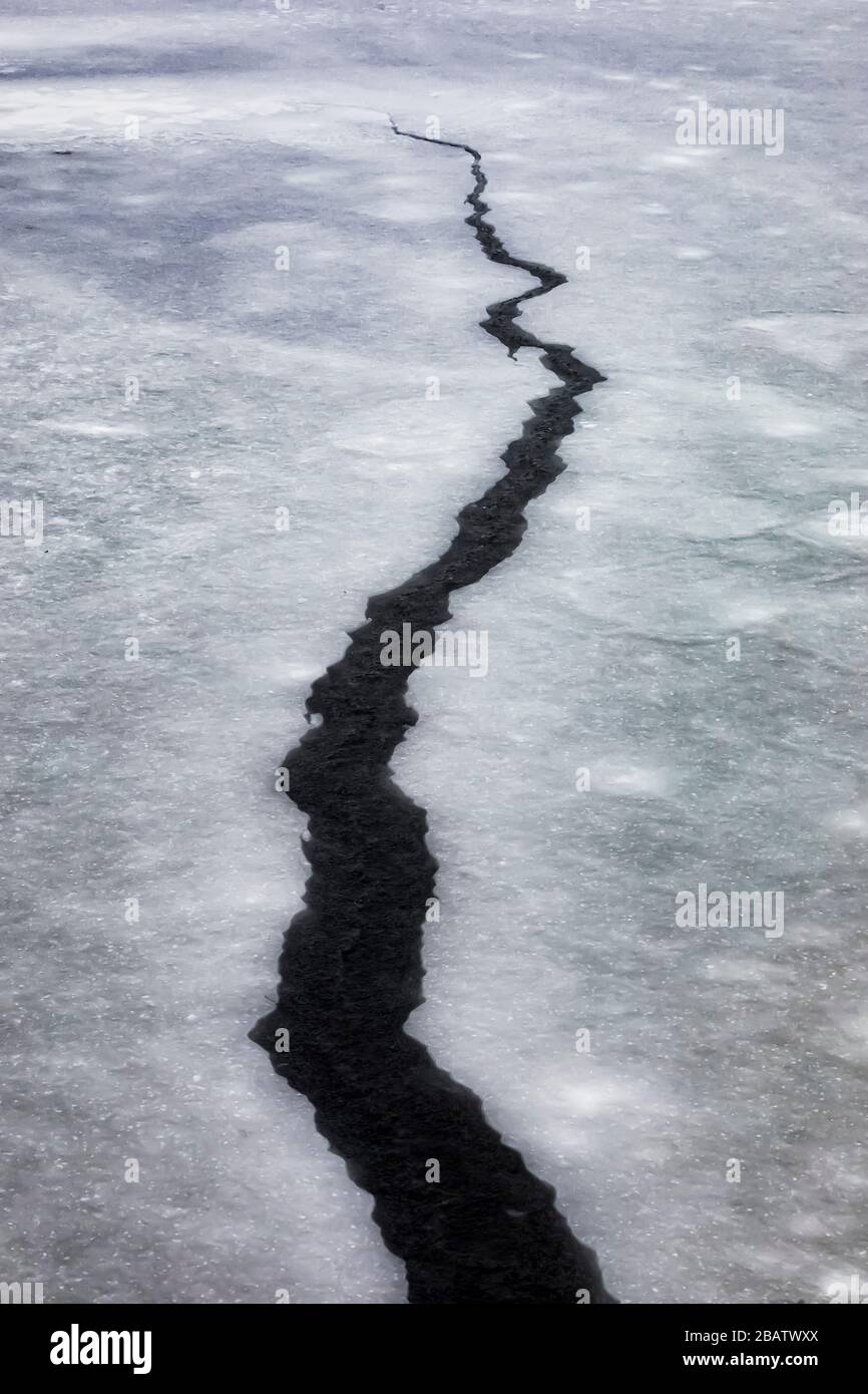 Crack in thin ice over a harbour on Fogo Island in Newfoundland, Canada ...