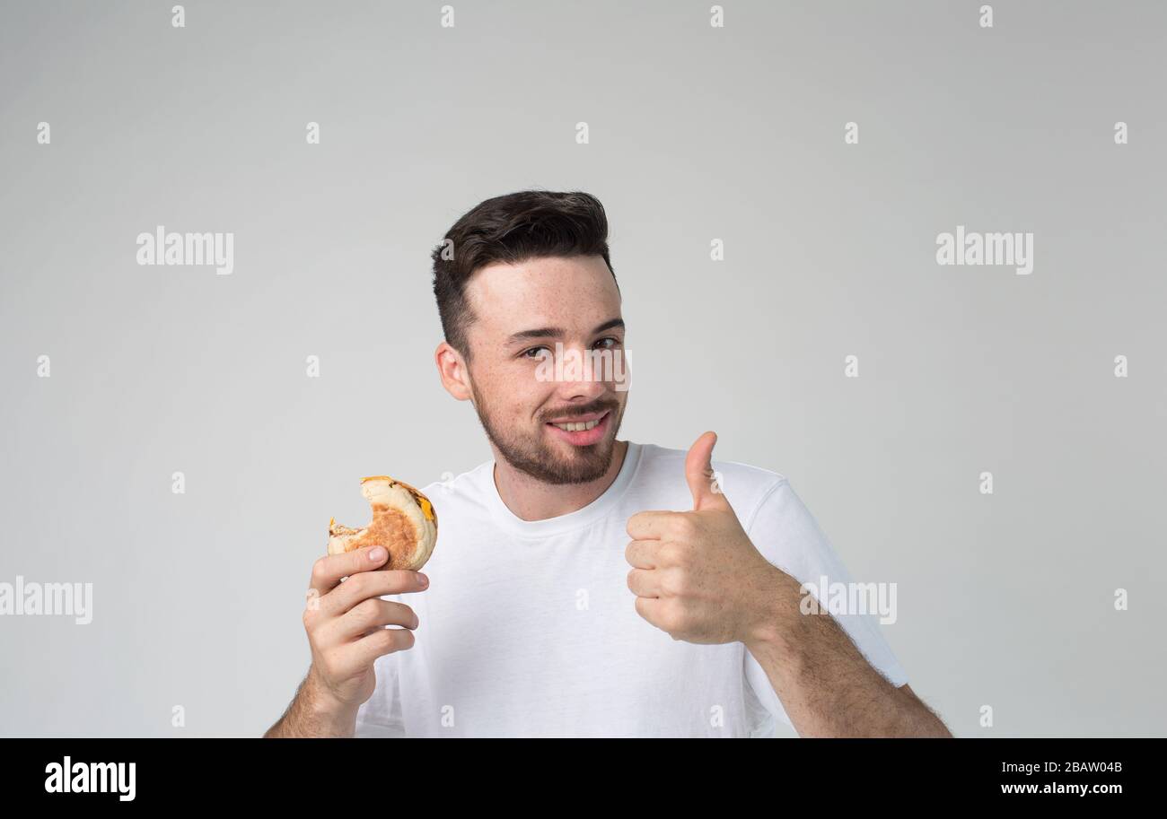 Young man isolated over background. Cheerful positive guy hold piece of ...