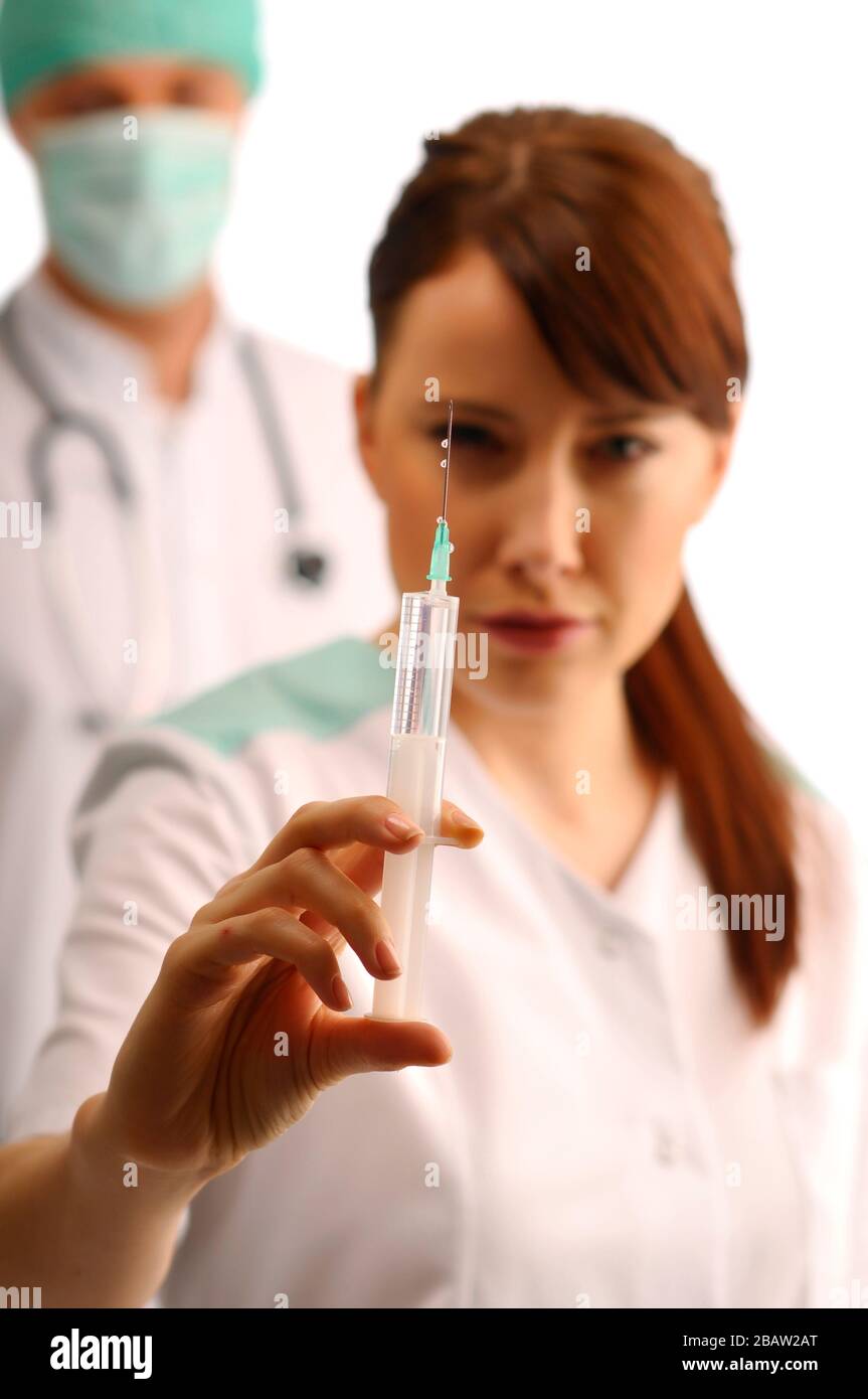 Medical assistant with an injection, doctor in behind Stock Photo - Alamy