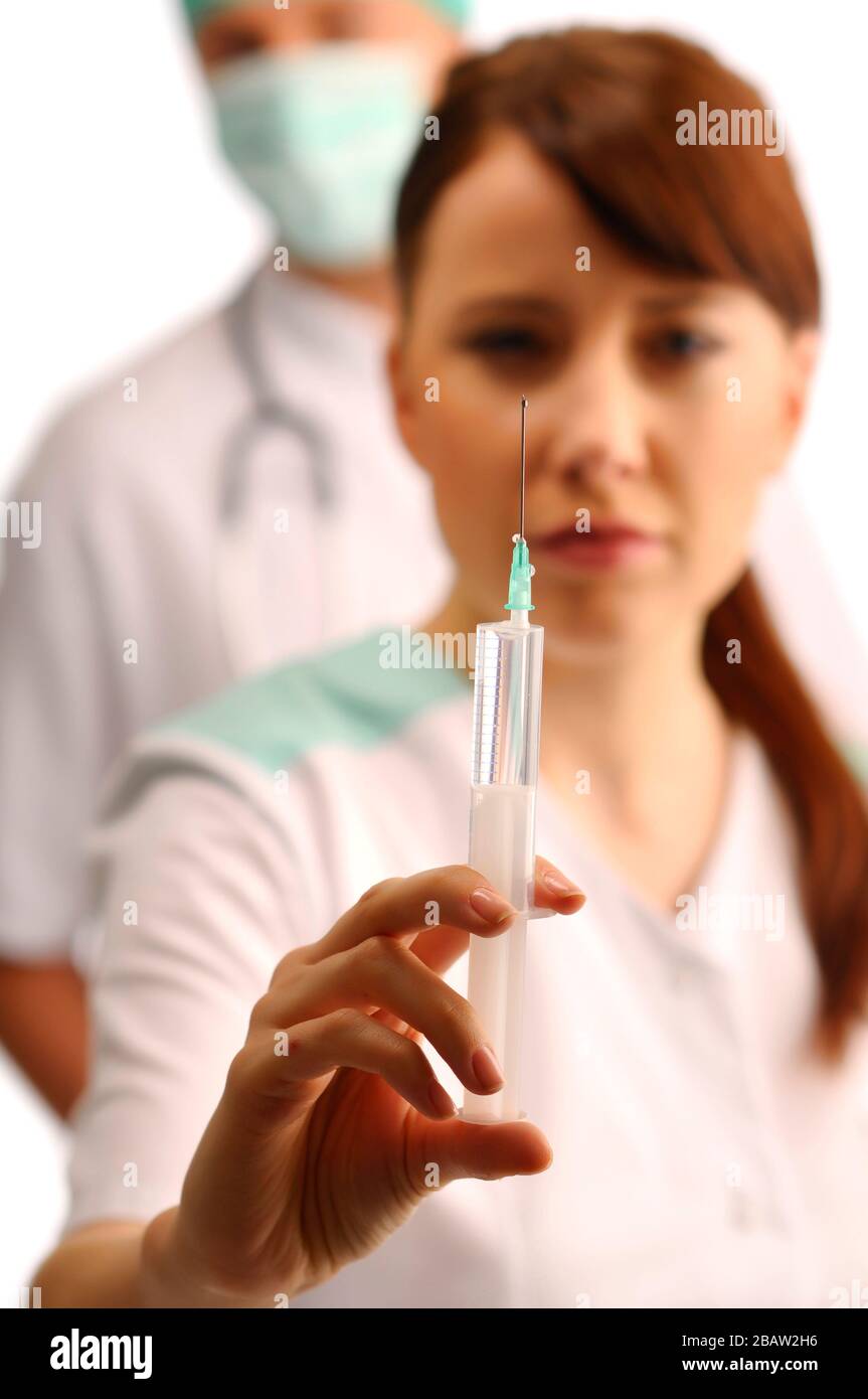 Medical assistant with an injection, doctor in behind Stock Photo - Alamy