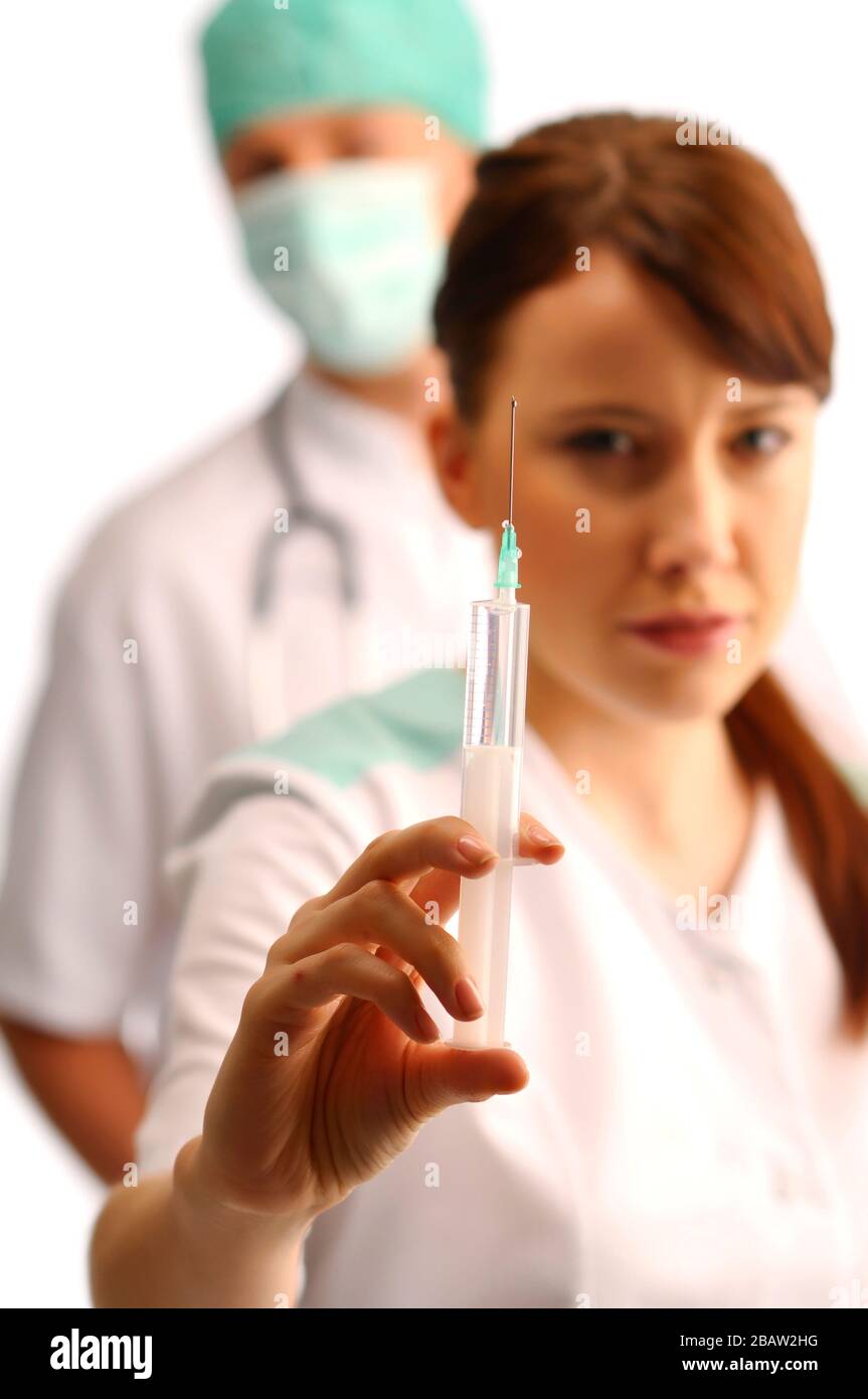 Medical assistant with an injection, doctor in behind Stock Photo - Alamy