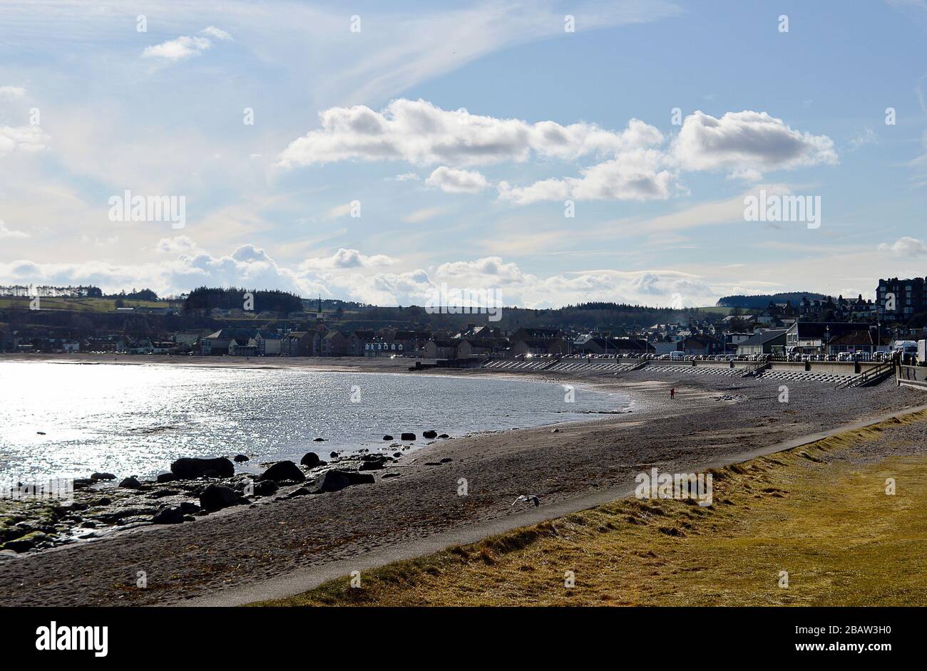 Sun on a silver North Sea looking back down the beach to Stonehaven ...