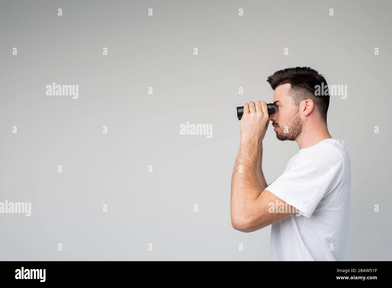 Young man isolated over background. Side view of guy looking forward ...