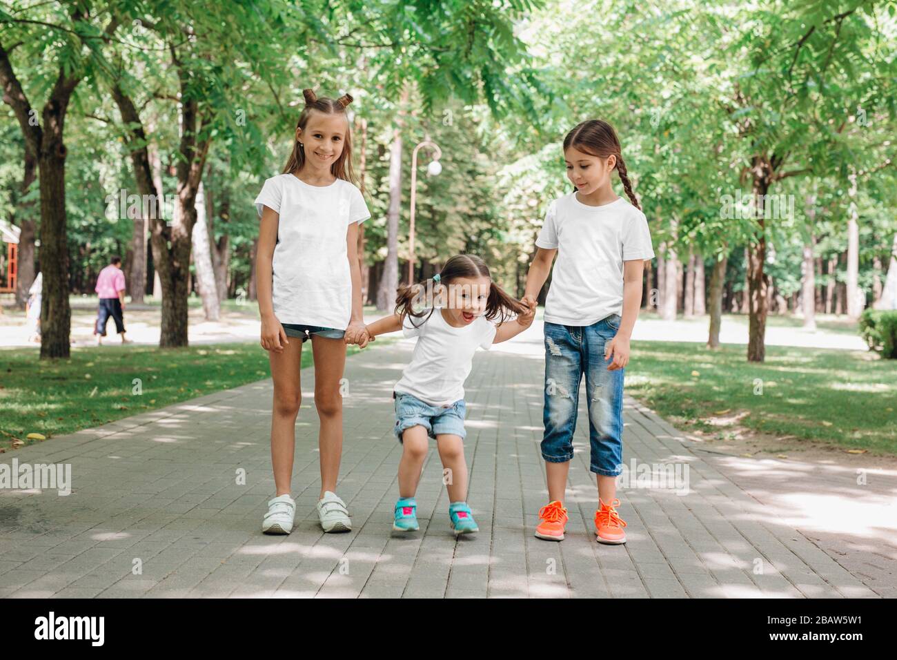 Three children stand hi-res stock photography and images - Alamy