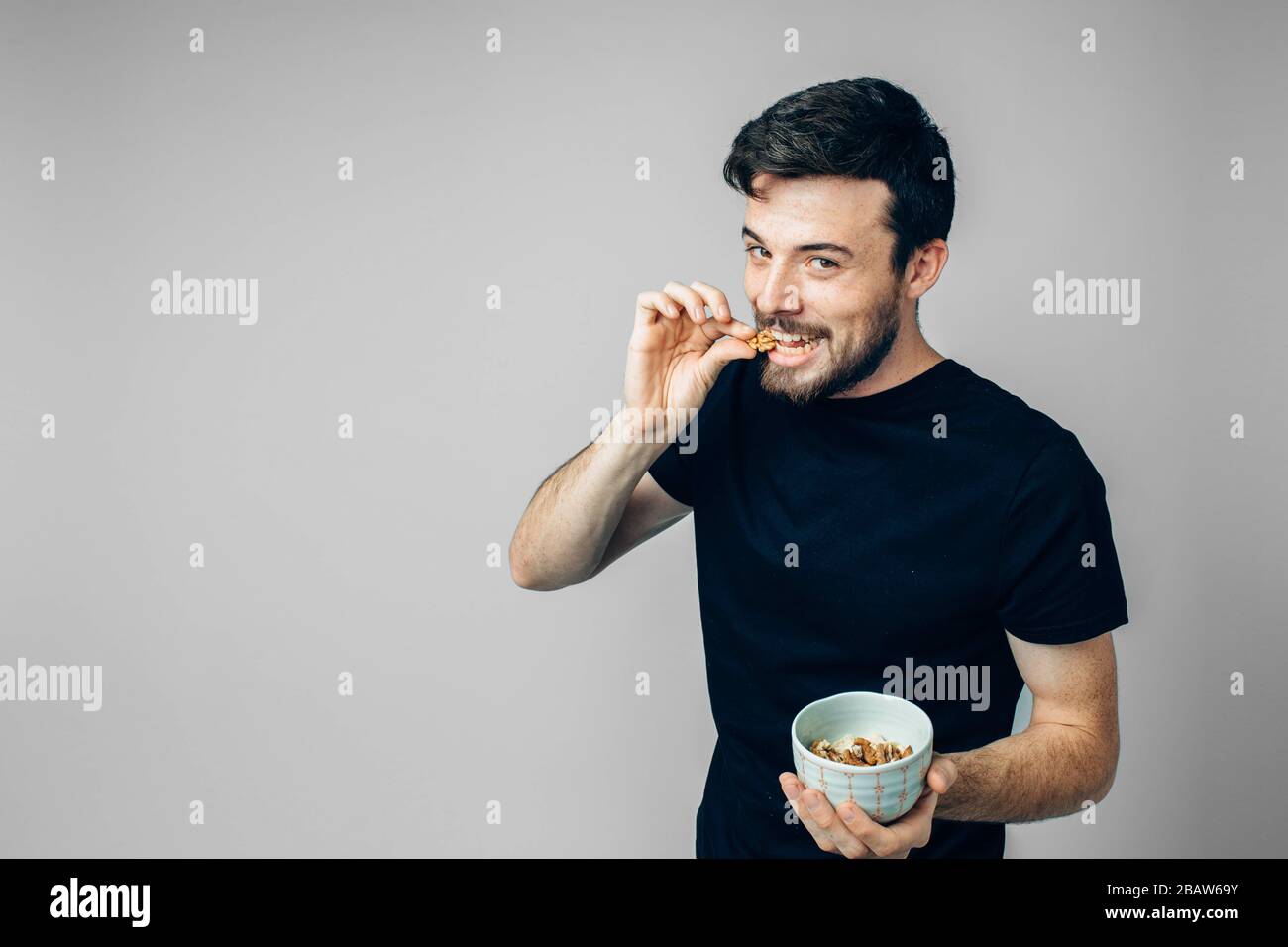Young man isolated over background. Side view of handsome guy biting ...
