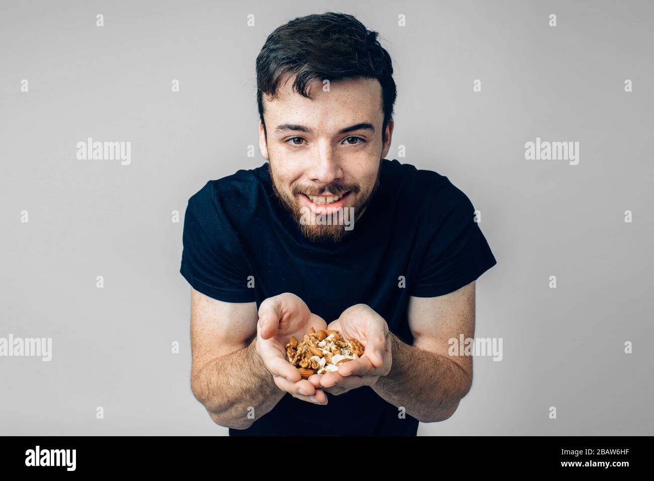 Young man isolated over background. Guy in casual black clothes hold ...