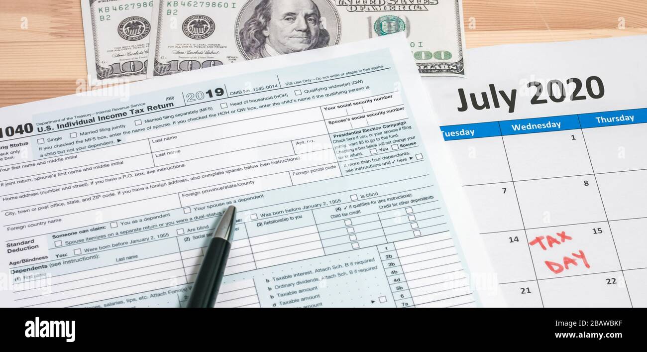 US 1040 tax day return form with 100 usd dollar bills and calendar ...