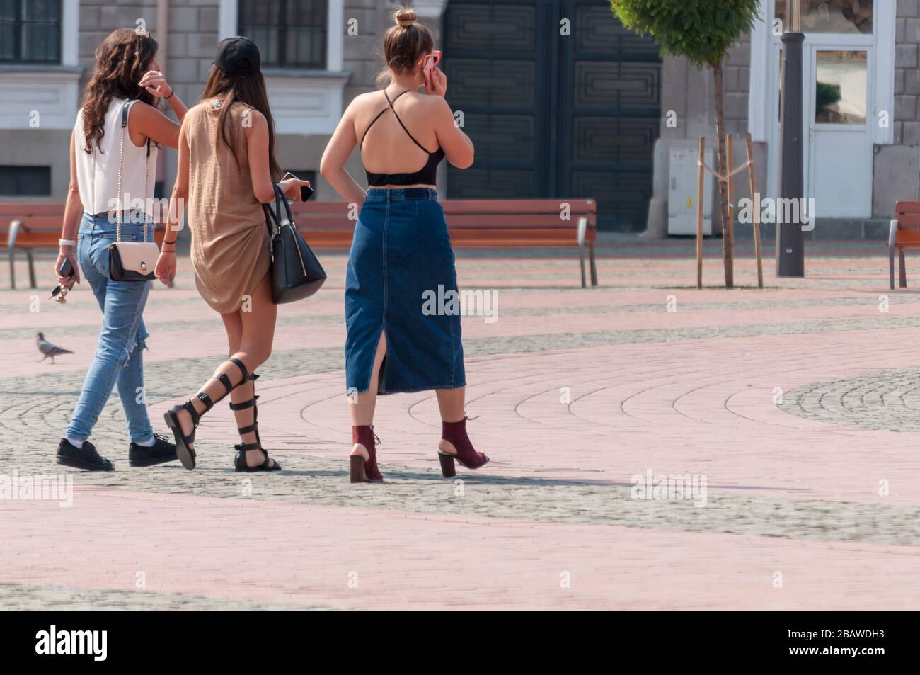 Three women walking on the street. Real people. View from behind Stock ...