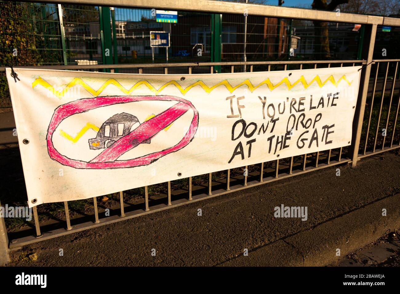 Banner painted by pupil, "If you are late don't drop at the gate ...