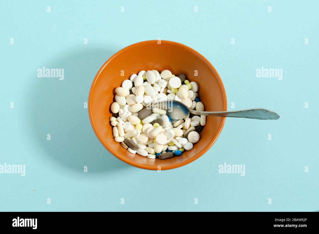 Medication with a spoon. Plate with medicines on a blue background ...