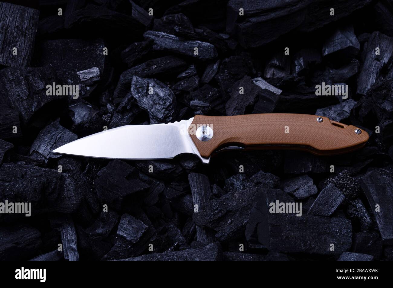 Pocket folding knife with a brown handle. Shiny knife on the corner ...