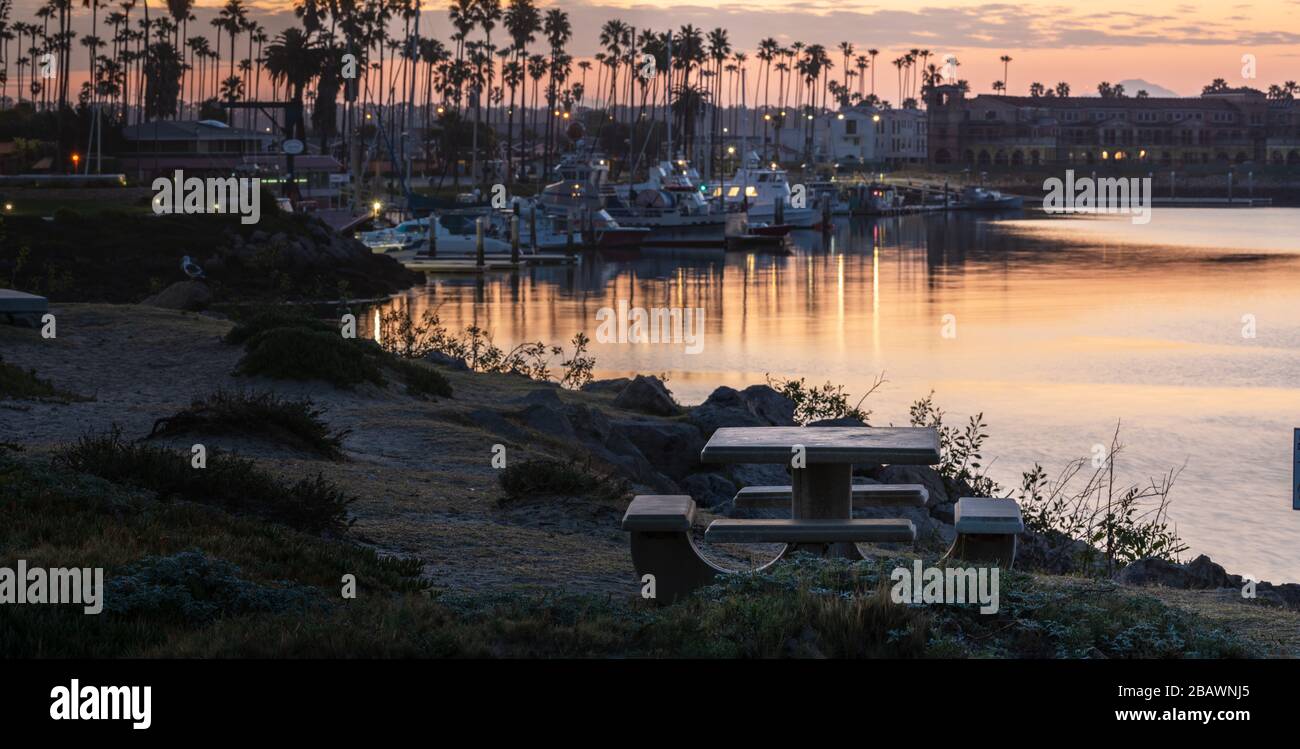 Marina park picnic table sits in foreground view of reflective water of ...