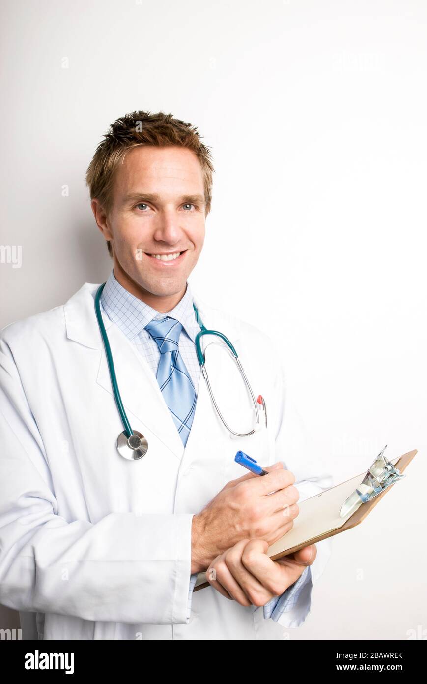 Portrait of smiling doctor in white lab coat taking notes on a clip ...