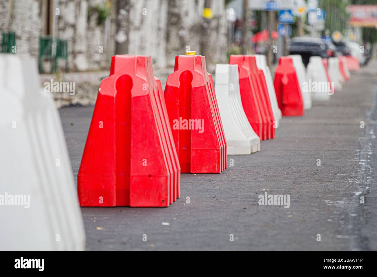 Red and white plastic barriers blocking the road for the time of repair ...