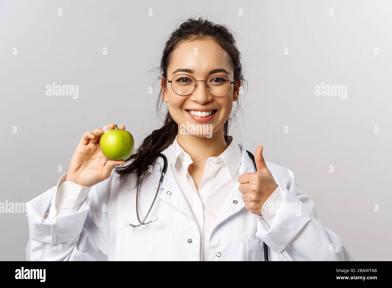 Portrait of young cheerful asian female doctor, therapist or ...