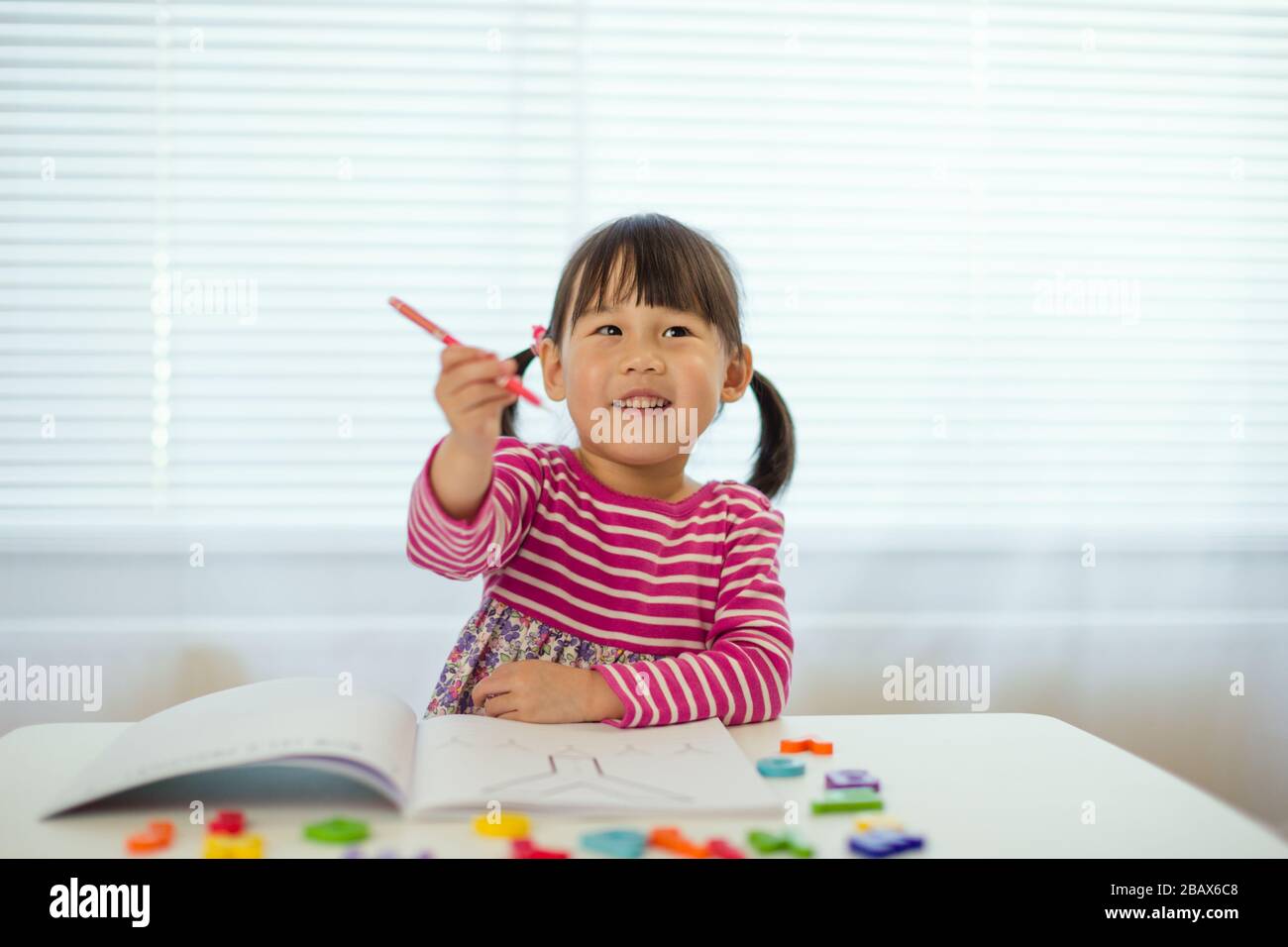 toddler girl practice writing letters for homeschooling Stock Photo - Alamy