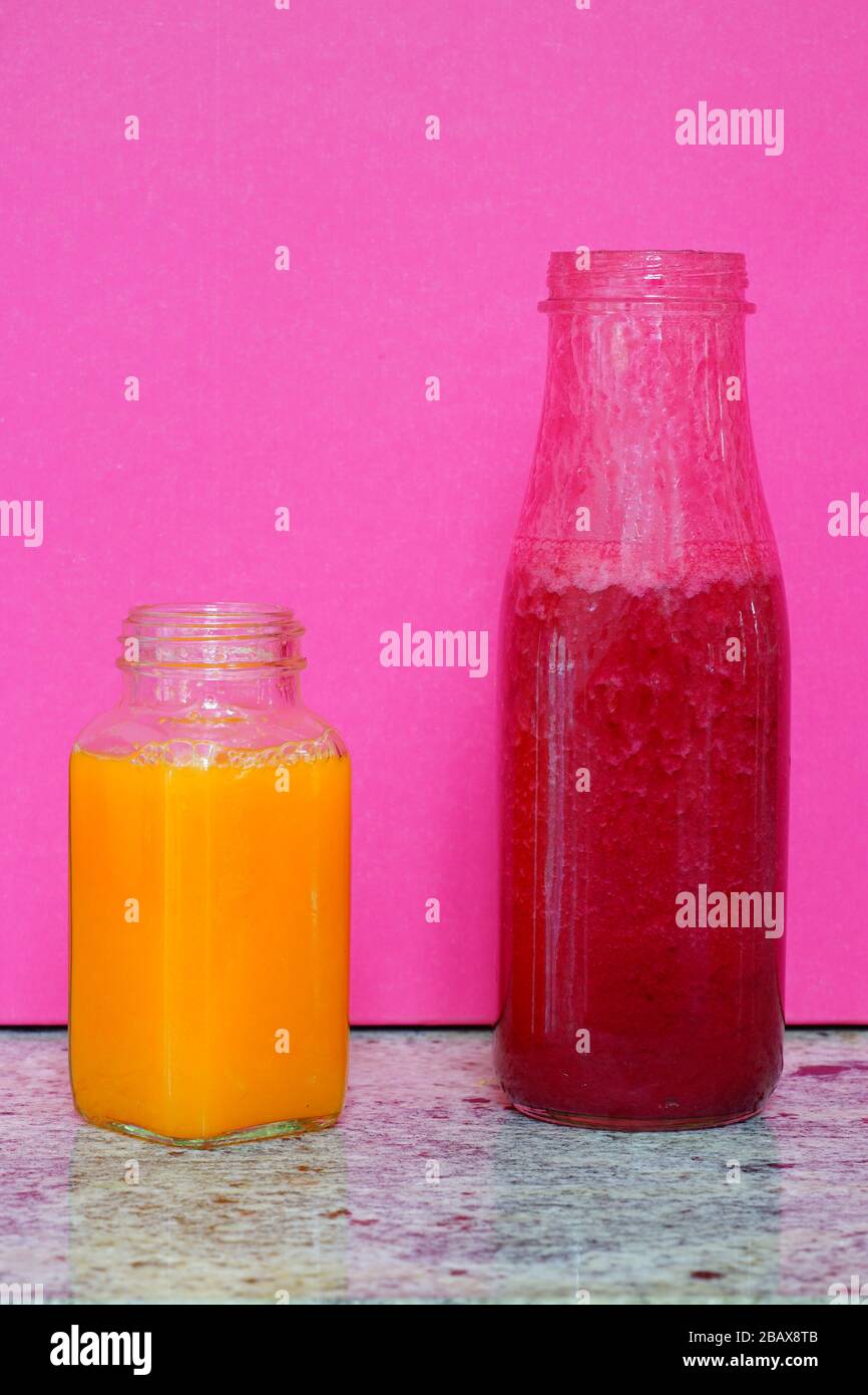 Glass bottles filled with colorful homemade beet smoothies Stock Photo ...